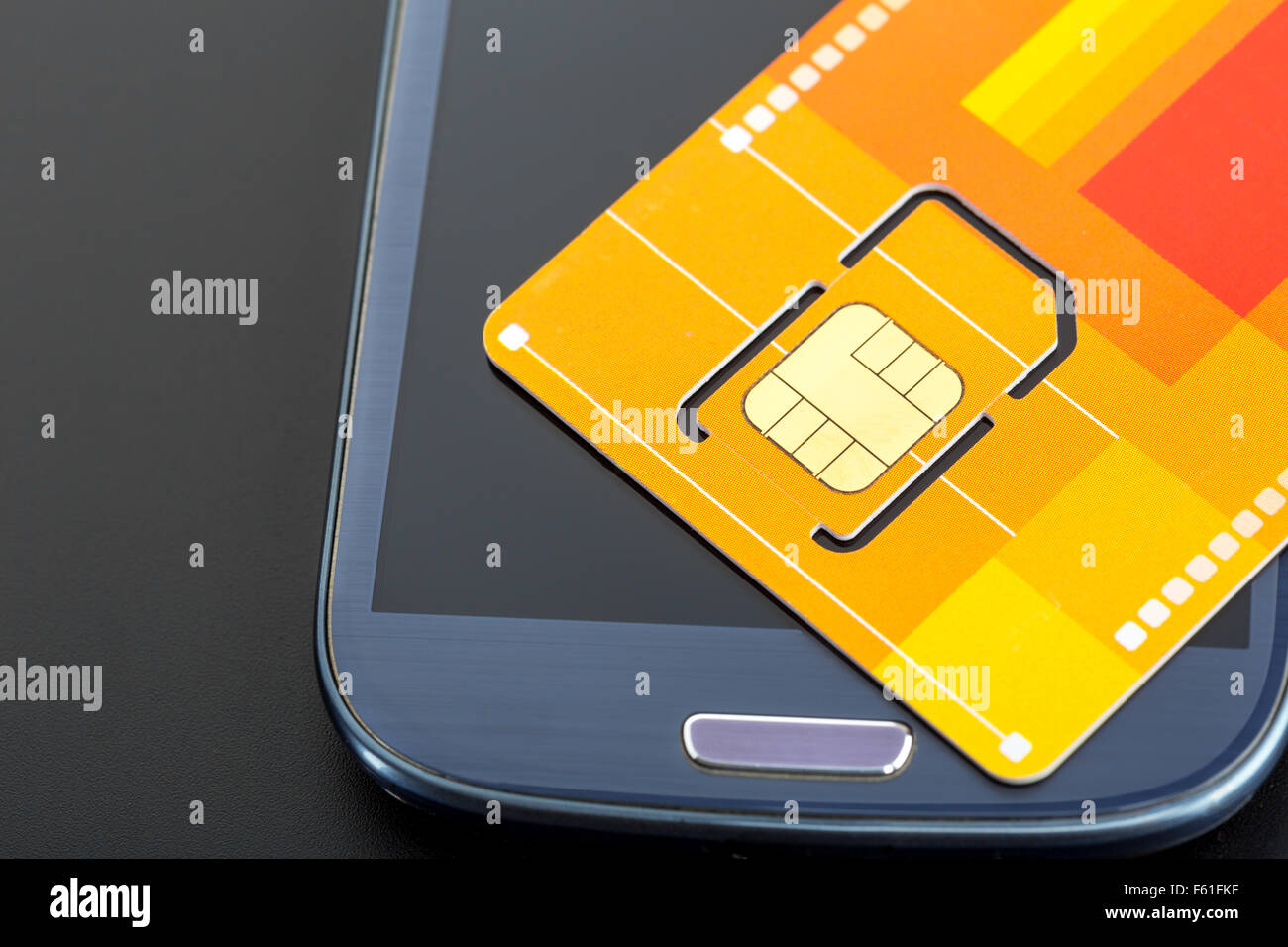 Yellow sim card on the phone against grey background Stock Photo - Alamy