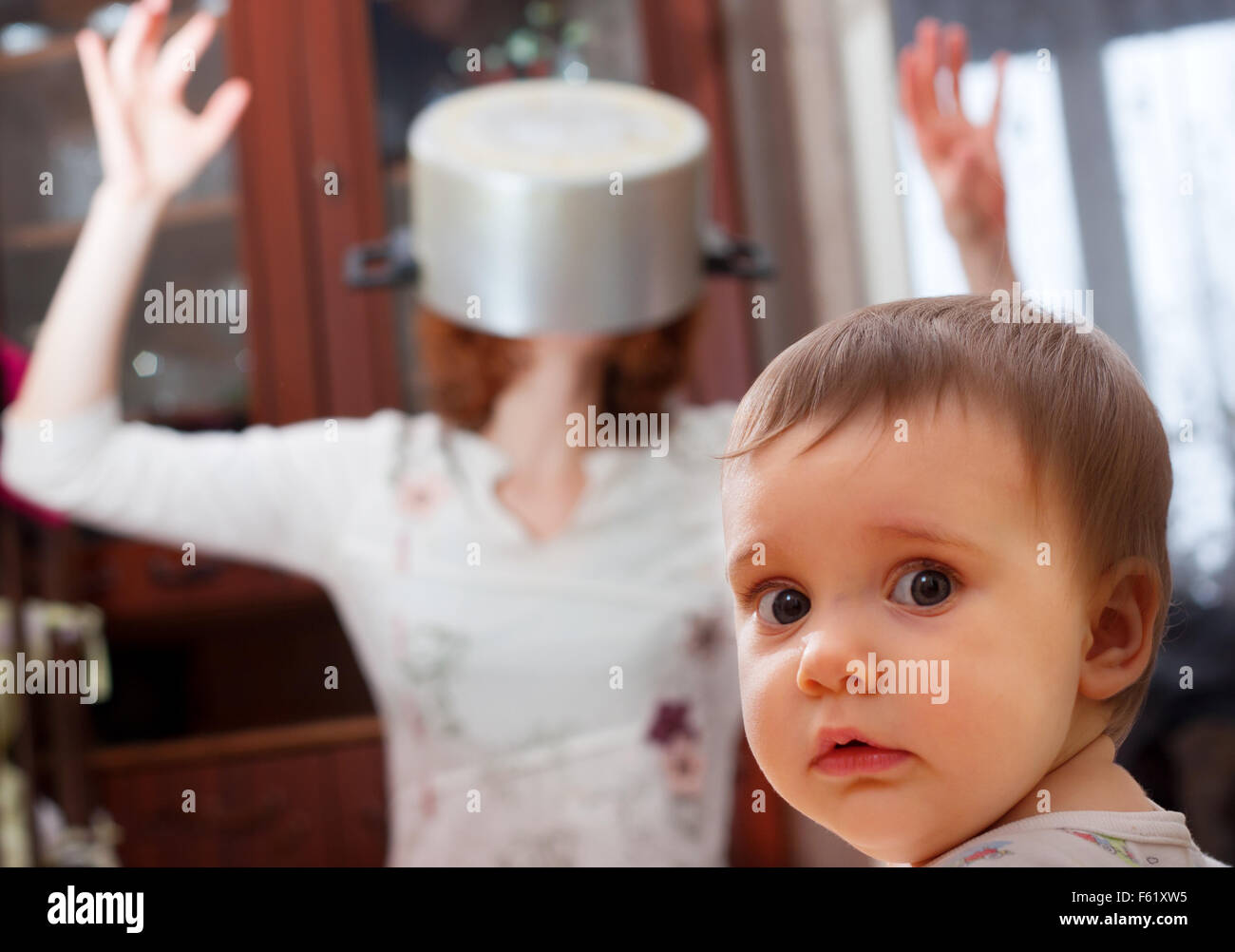 Portrait of scared baby against crazy mother with pan on head Stock ...