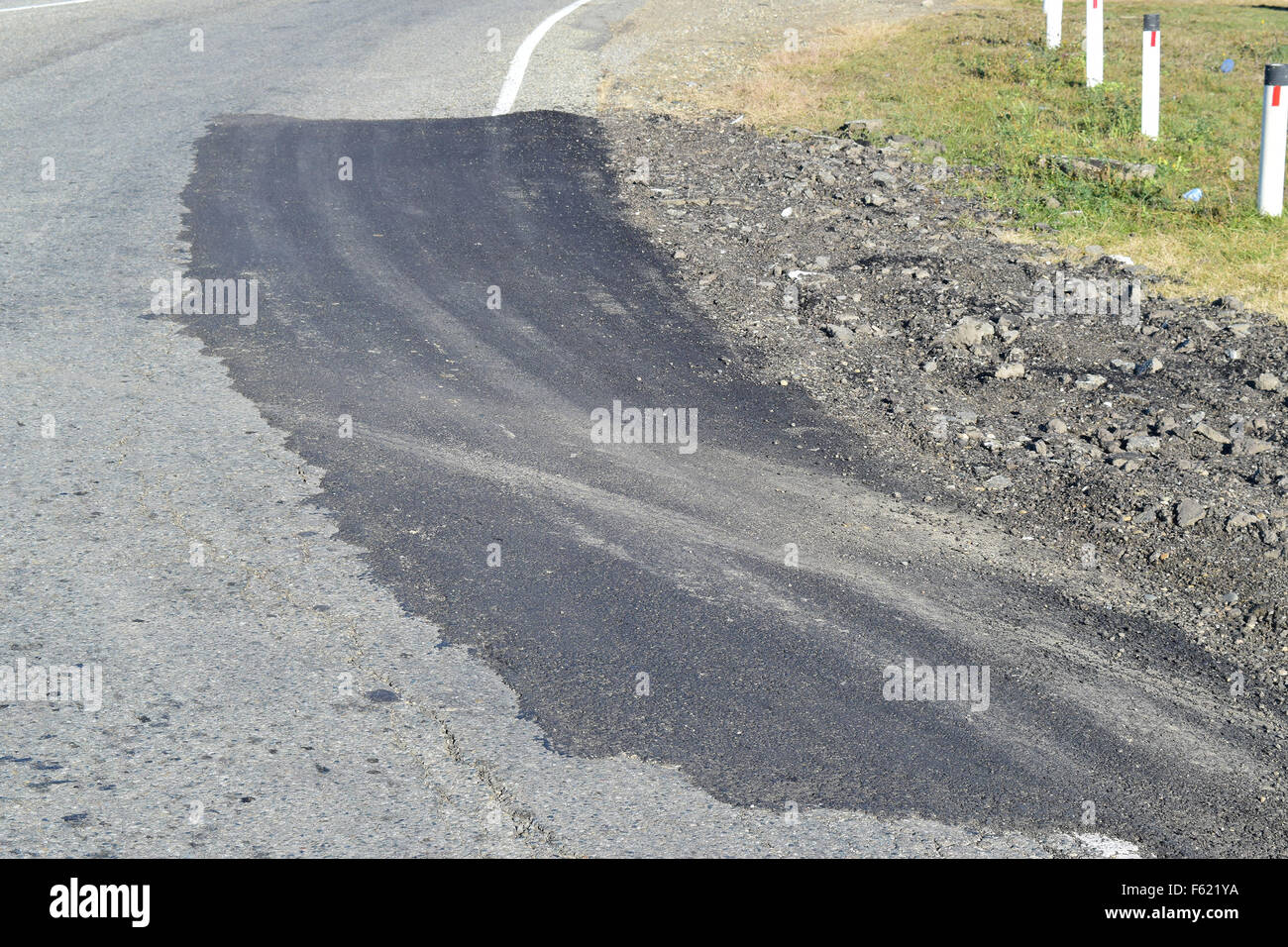 Repair of an asphalt road surfacing. A patch on asphalt Stock Photo - Alamy