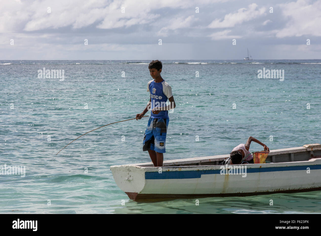 Two African boys are fishing on a boat Stock Photo - Alamy