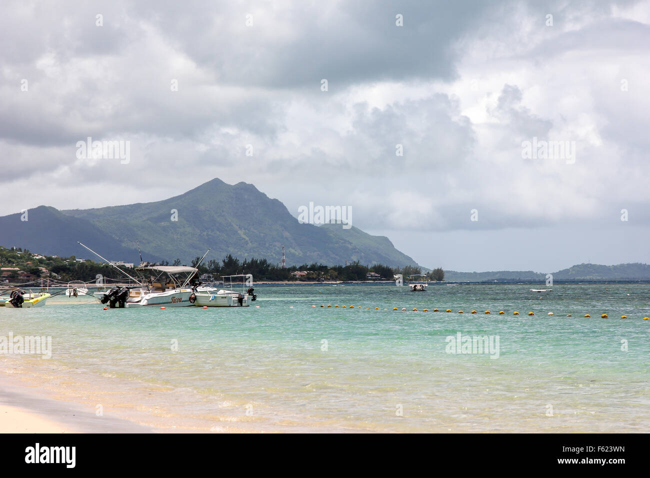 clear sea and beautiful beach with a mountain background in Mauritius ...