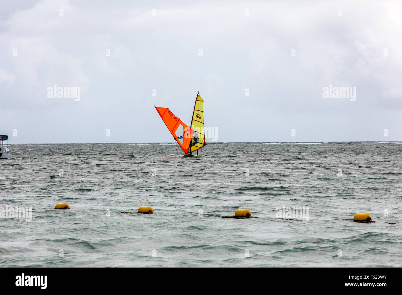 a sailing boat with orange and yellow sails on the sea Mauritius ...