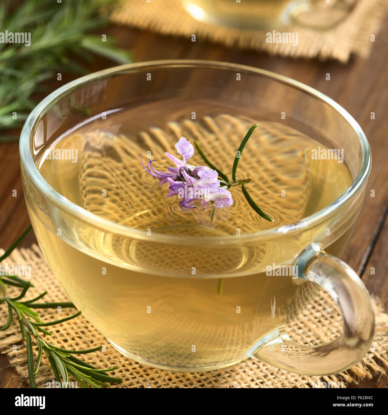 Freshly prepared rosemary herbal tea in glass cup, garnished with ...