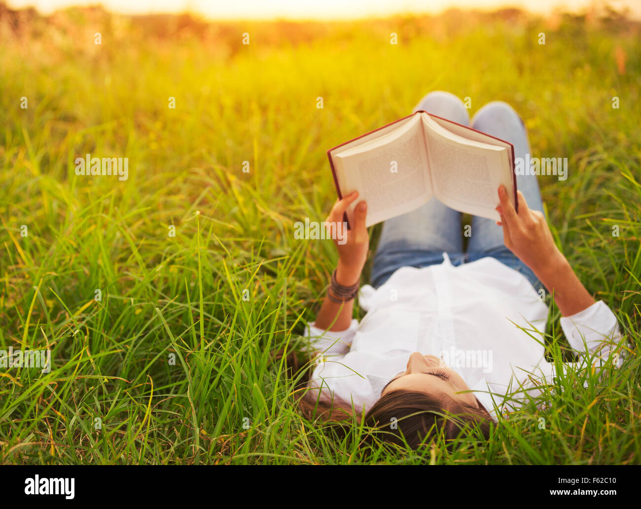 Young Woman Enjoying a Book Reading Outdoors Stock Photo - Alamy