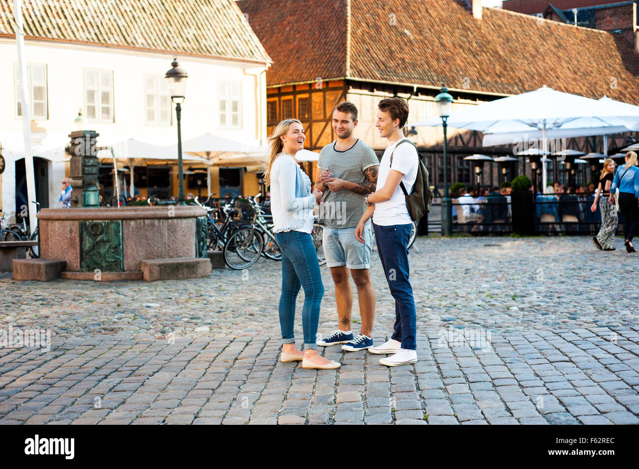Full length of friends standing on street in city Stock Photo - Alamy
