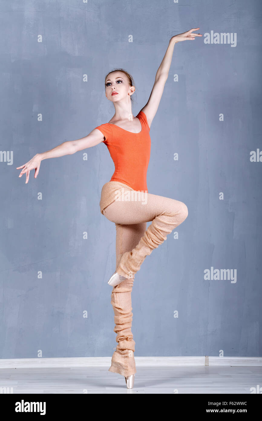 Slender young ballerina rehearses dance. Girl in pointe standing on one ...