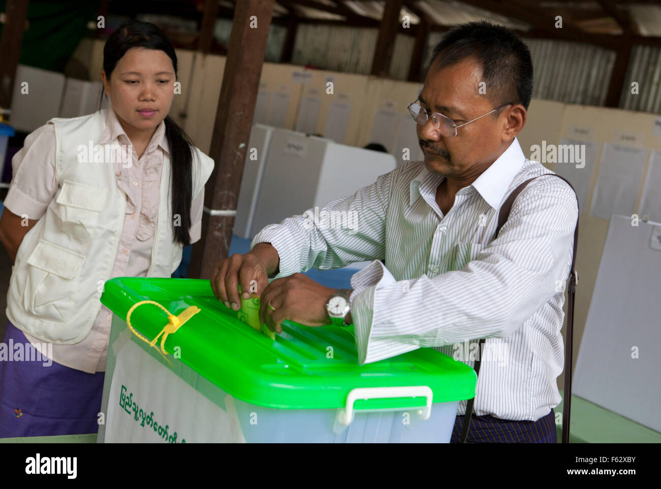 Burmese people vote, at a polling station, during the first general ...