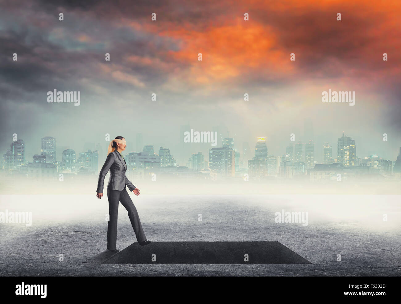Businesswoman blindfolded is going to a deep pitfall Stock Photo - Alamy