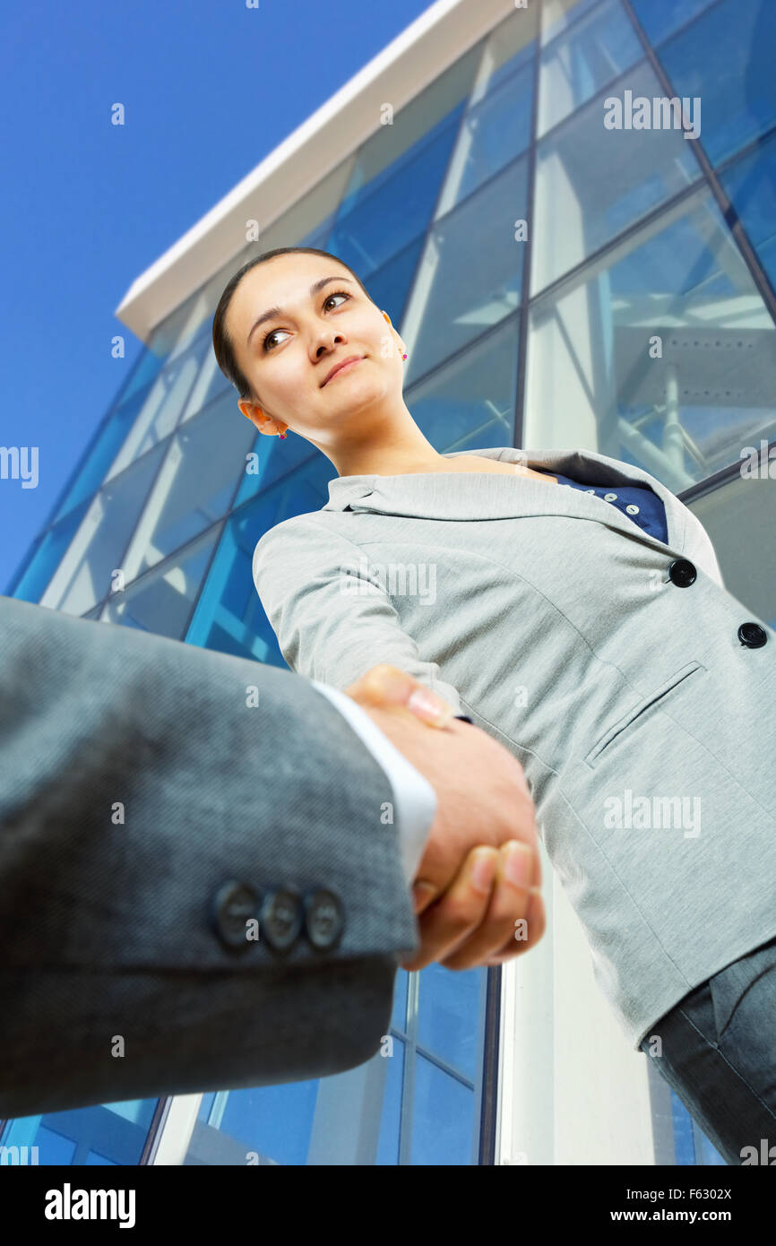 Cheerful businesslady and client handshaking Stock Photo - Alamy