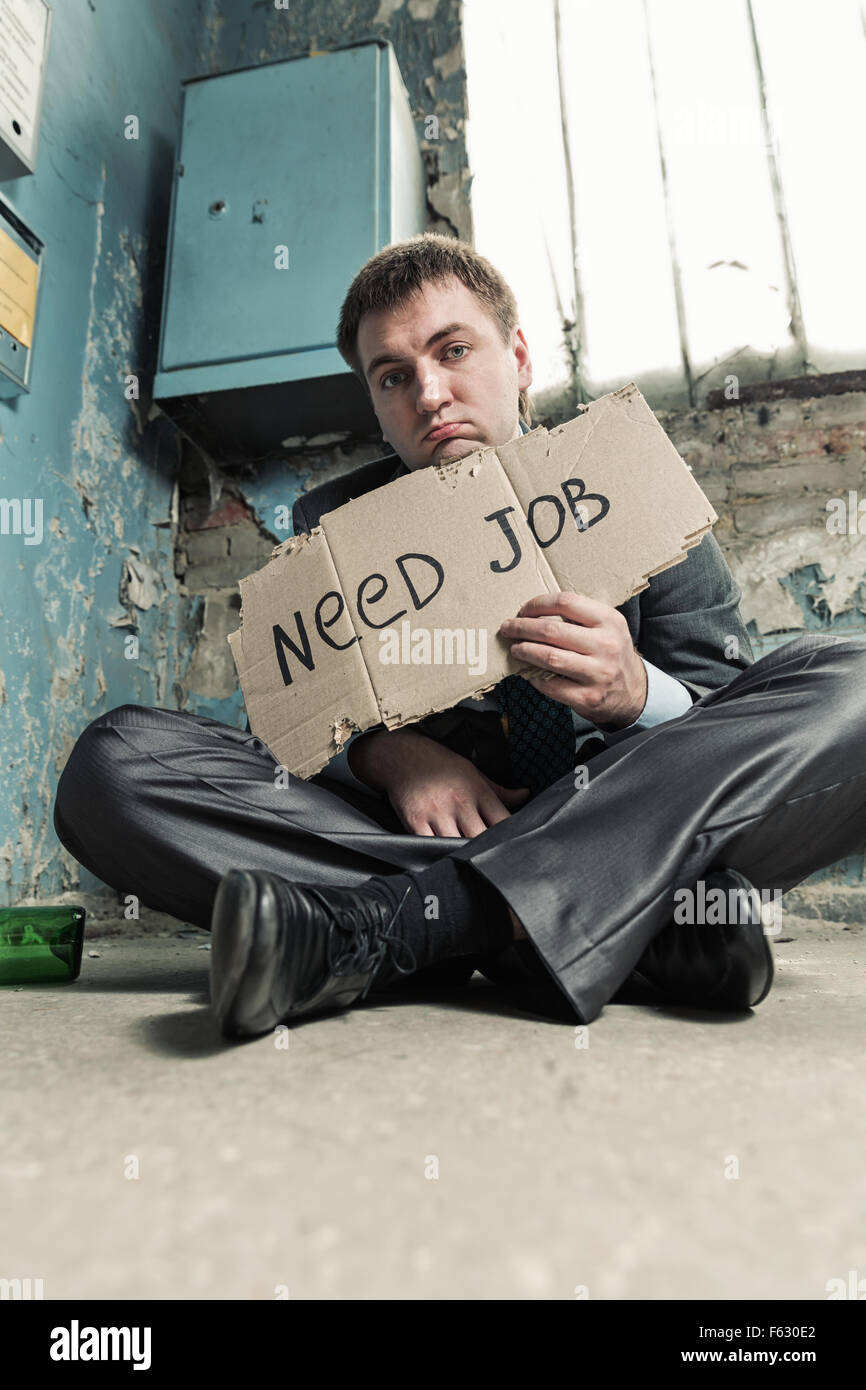 Homeless businessman holding sign asking for new job Stock Photo - Alamy