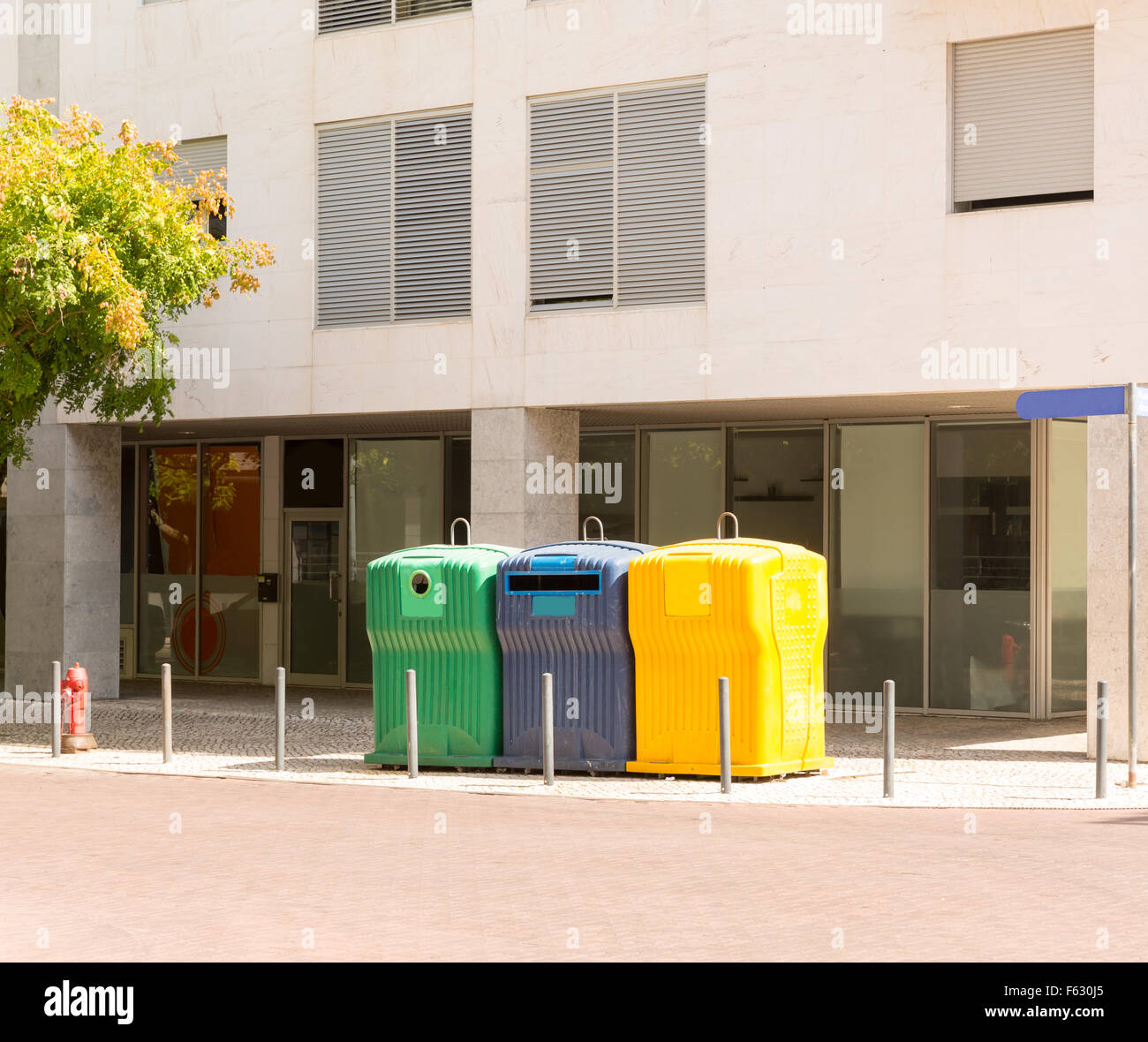 Tree colored plastic trash cans on the street Stock Photo - Alamy