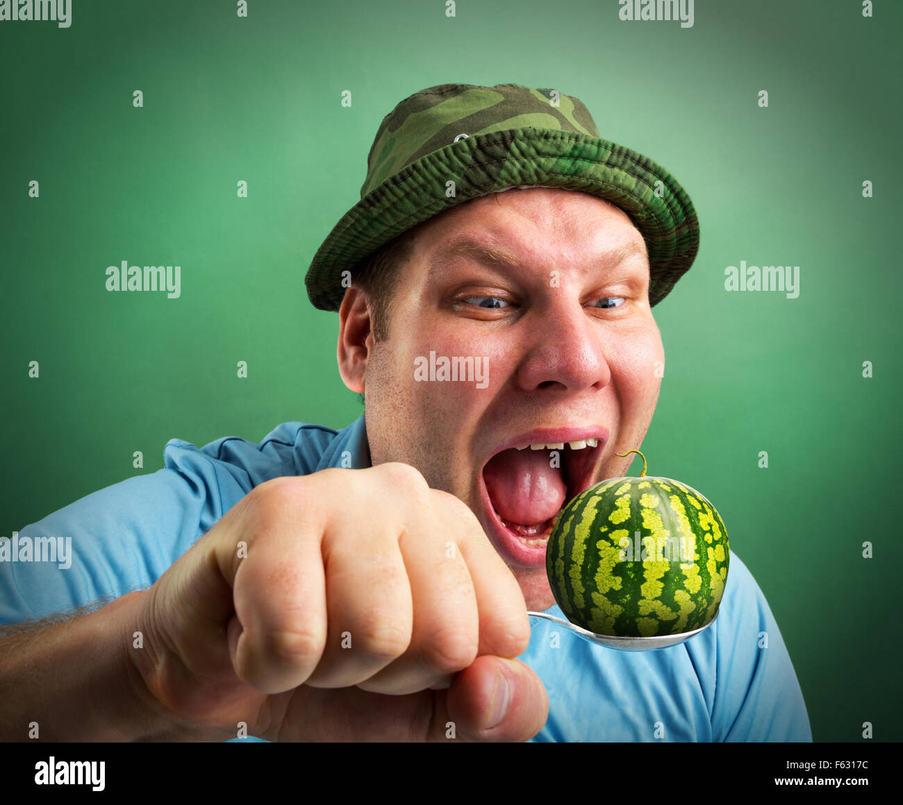 Bizarre man preparing to eat small watermelon on spoon Stock Photo - Alamy