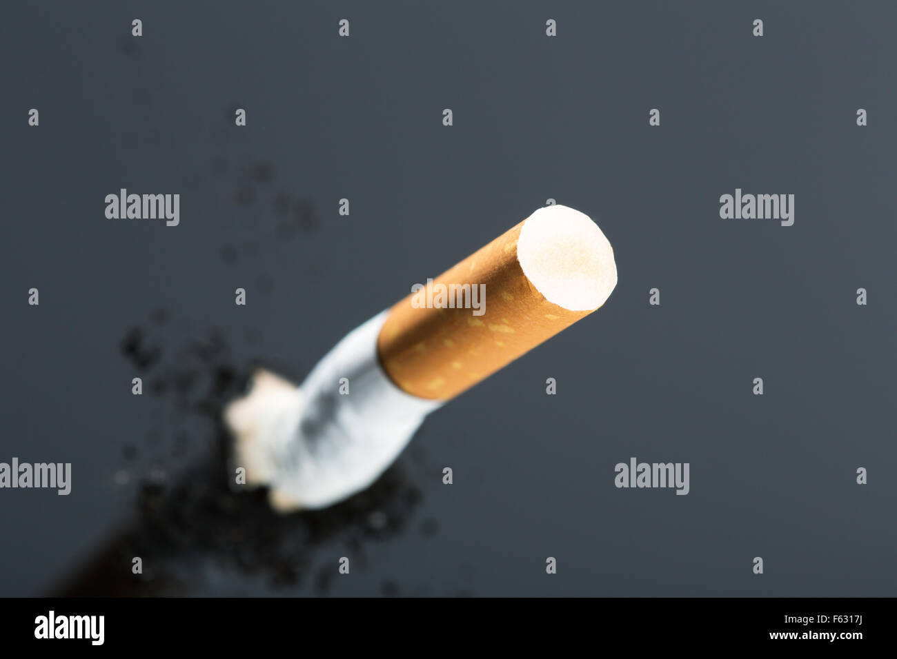 Cigarette butt on gray with reflection Stock Photo - Alamy