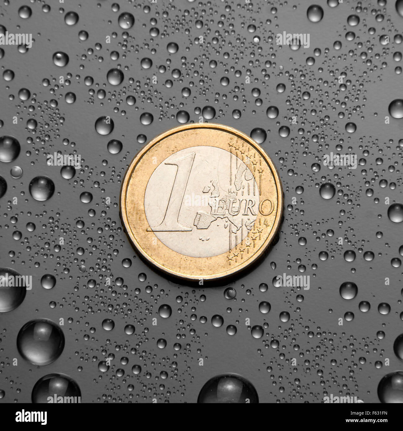 One EURO coin with water drops Stock Photo - Alamy