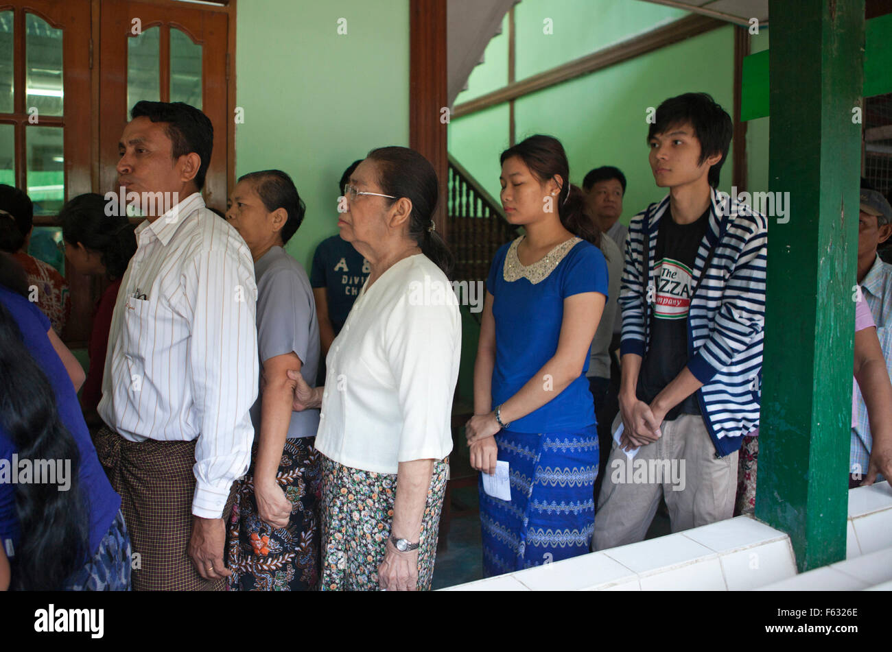 Burmese voters wait in line at a polling station during the first ...
