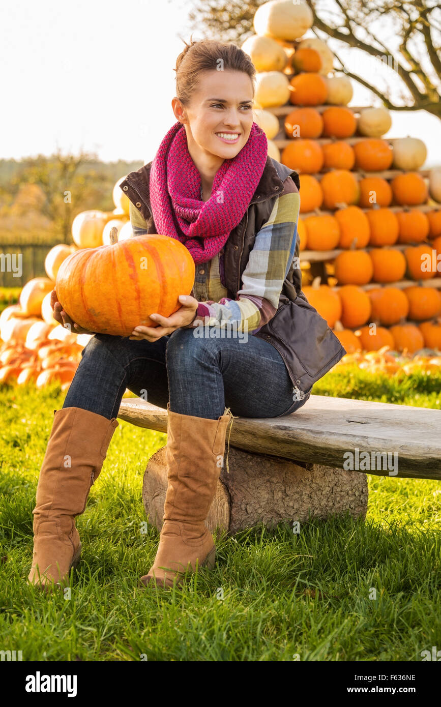 Portrait of beautiful smiling woman sitting on the bench and holding ...