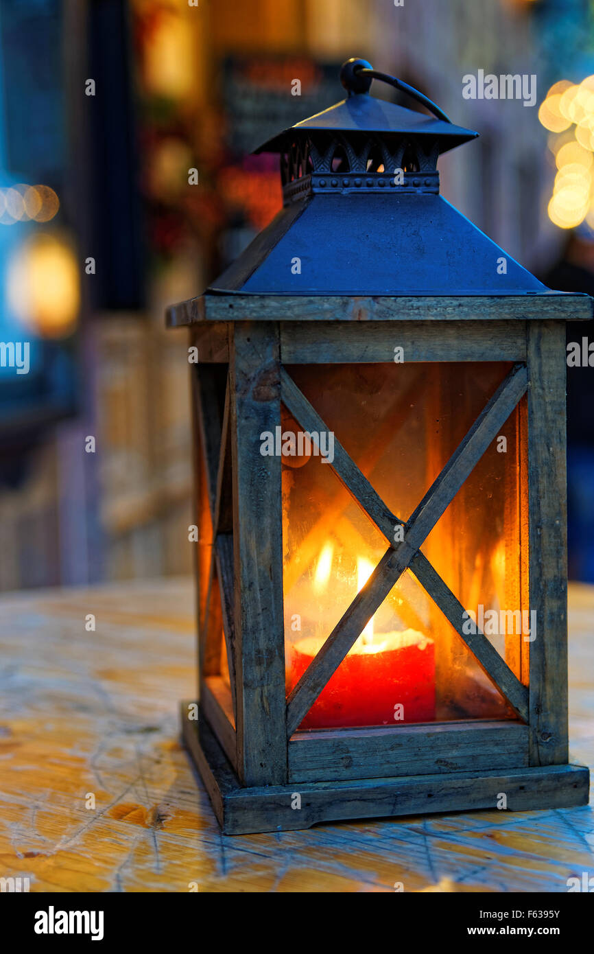 Burning lantern on wooden surface and blurred background. Garmisch ...