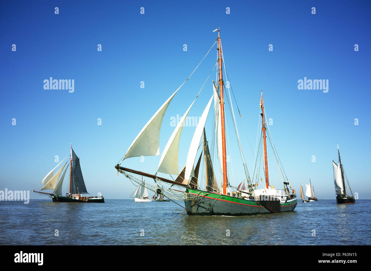Blue color image of a fleet of traditional sailing ships on the ocean ...