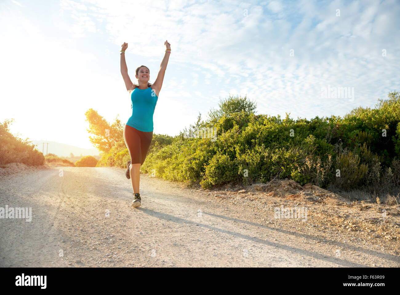 Happy girl jogging outdoors at sunset hour Stock Photo - Alamy