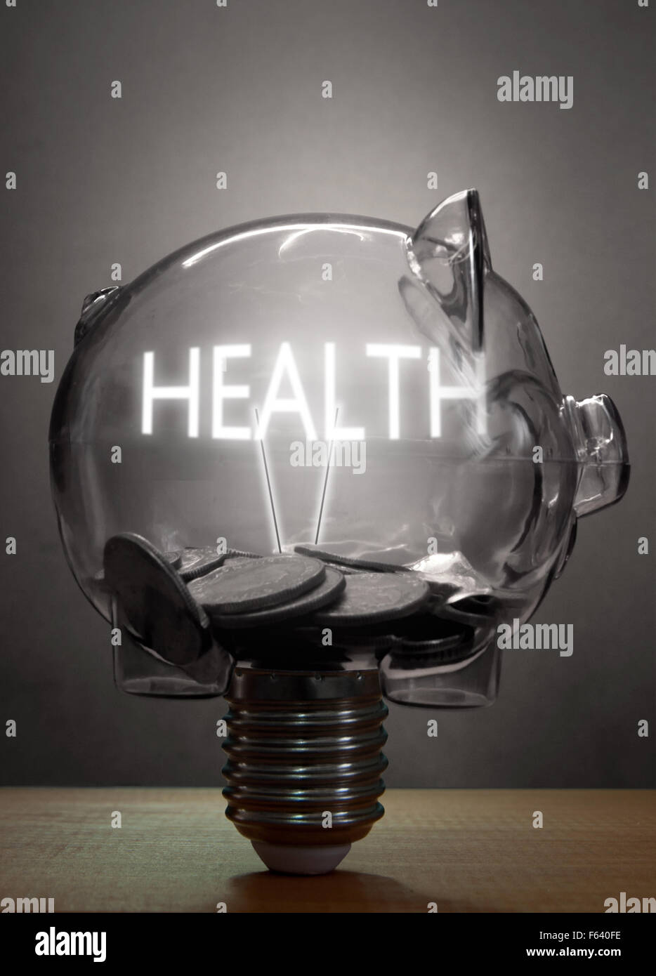 Piggybank light bulb with health lit text inside Stock Photo - Alamy