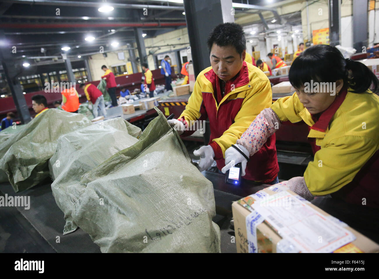 Shanghai, China. 11th Nov, 2015. Workers sort out packages at a sorting ...