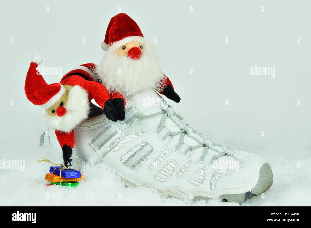 Santa Claus with sweets inside a white sports shoe on white, snowy ...