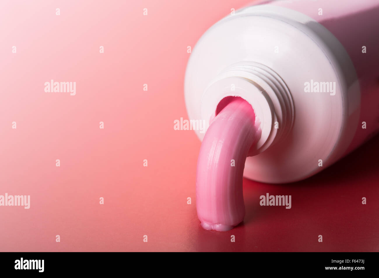 Pink toothpaste squeezing out of tube Stock Photo - Alamy