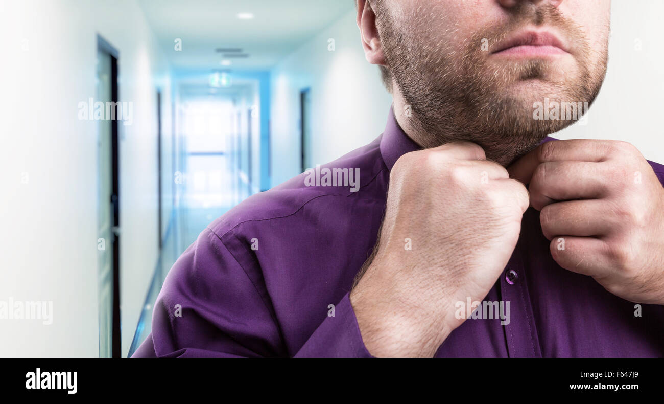 Bearded man buttons his shirt in office corridor Stock Photo - Alamy