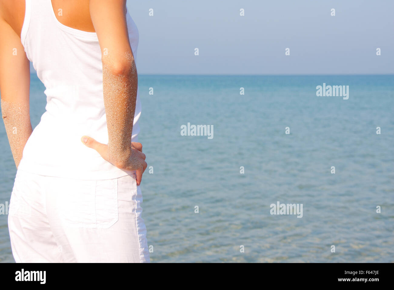 Tan woman in white on the beach Stock Photo - Alamy