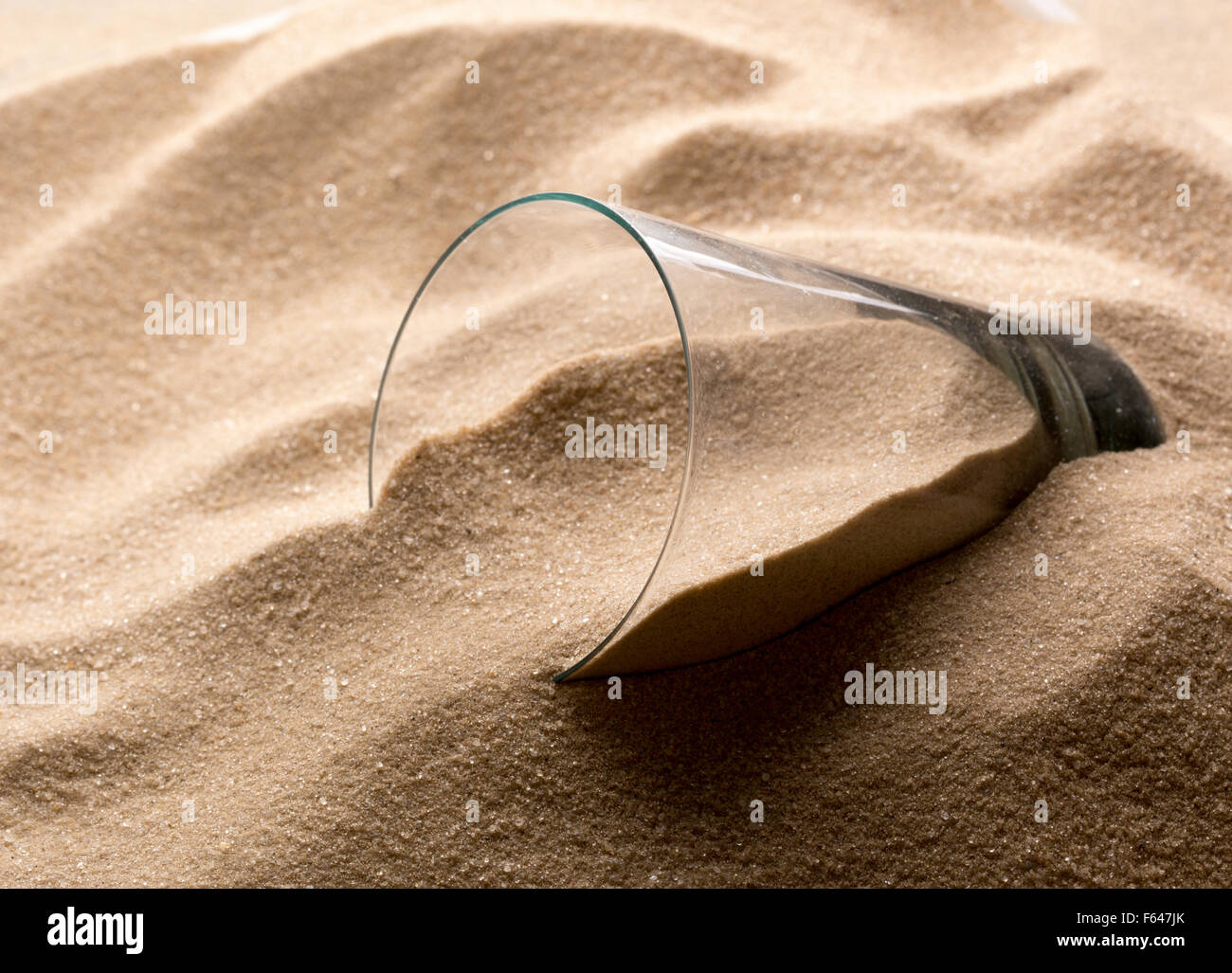 Closeup of empty glass in sand Stock Photo - Alamy