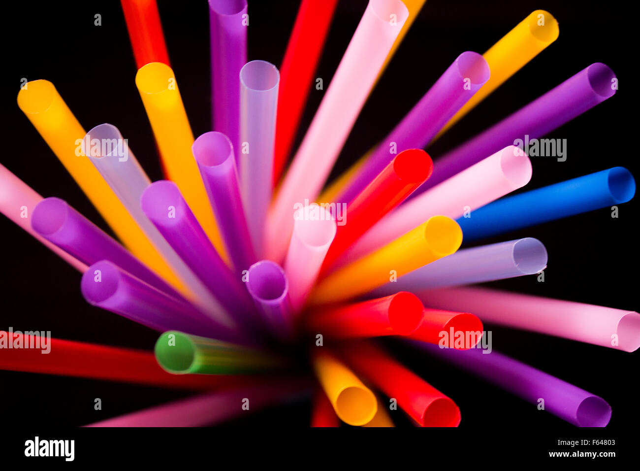 Drinking straws of all colors on black background Stock Photo - Alamy