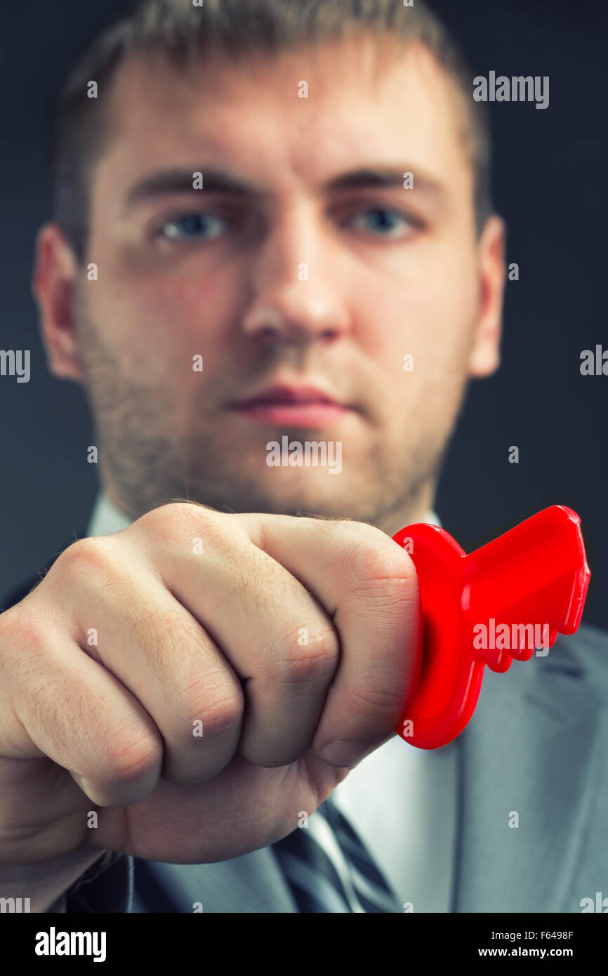 Solution concept - Businessman using red toy key Stock Photo - Alamy