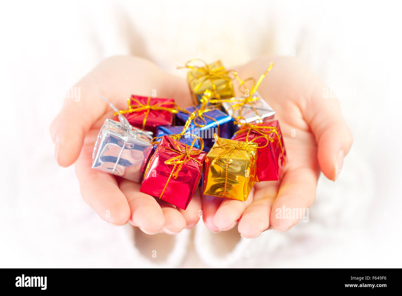 Small color christmas gifts in palms of hands Stock Photo - Alamy