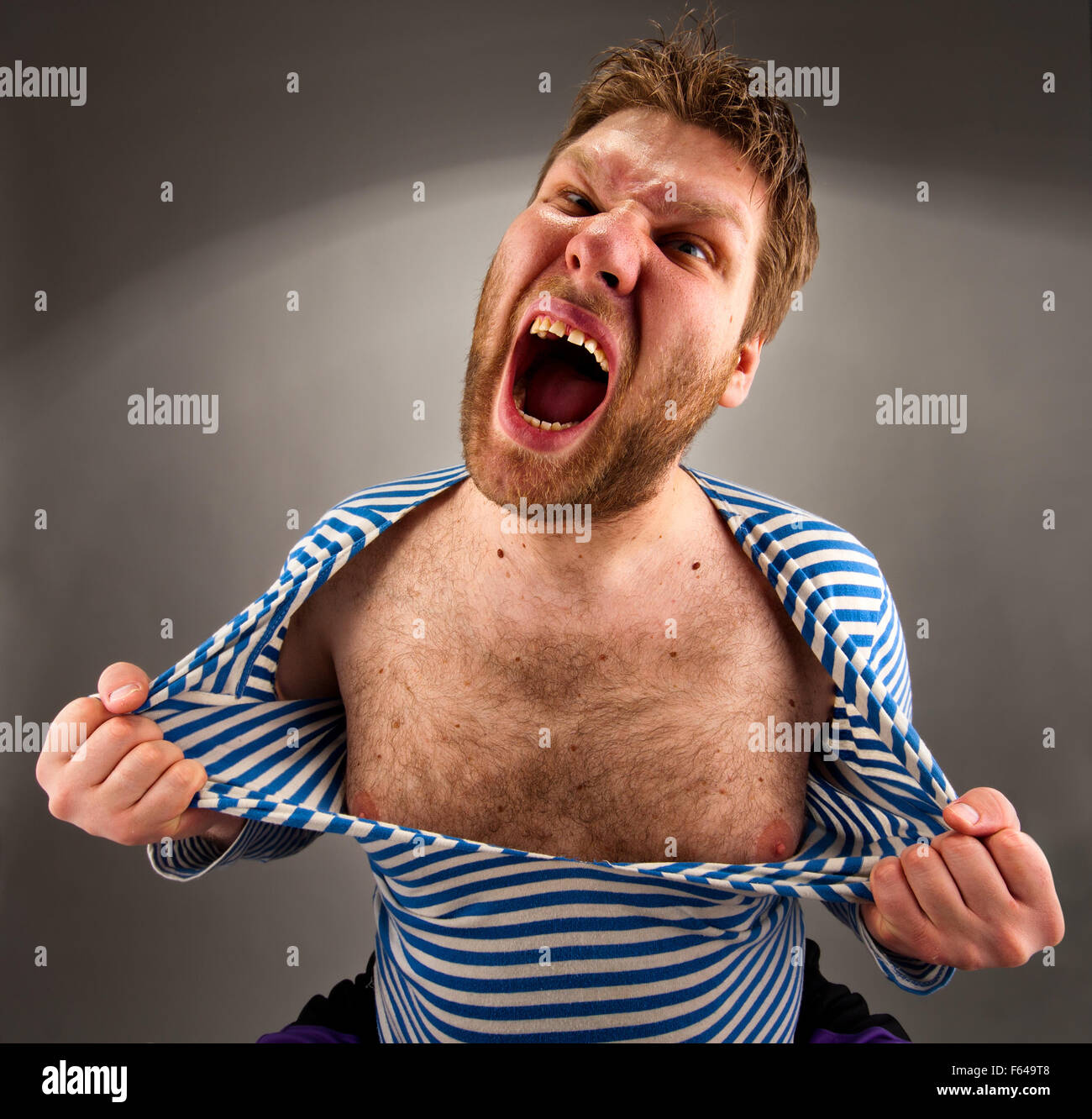 Angry prisoner bandit tearing clothing on himself Stock Photo - Alamy