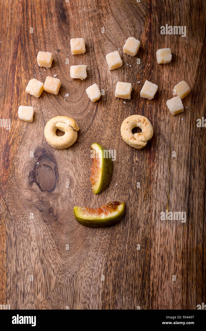 funny food face made with fig, parmesan and taralli on wood Stock Photo ...