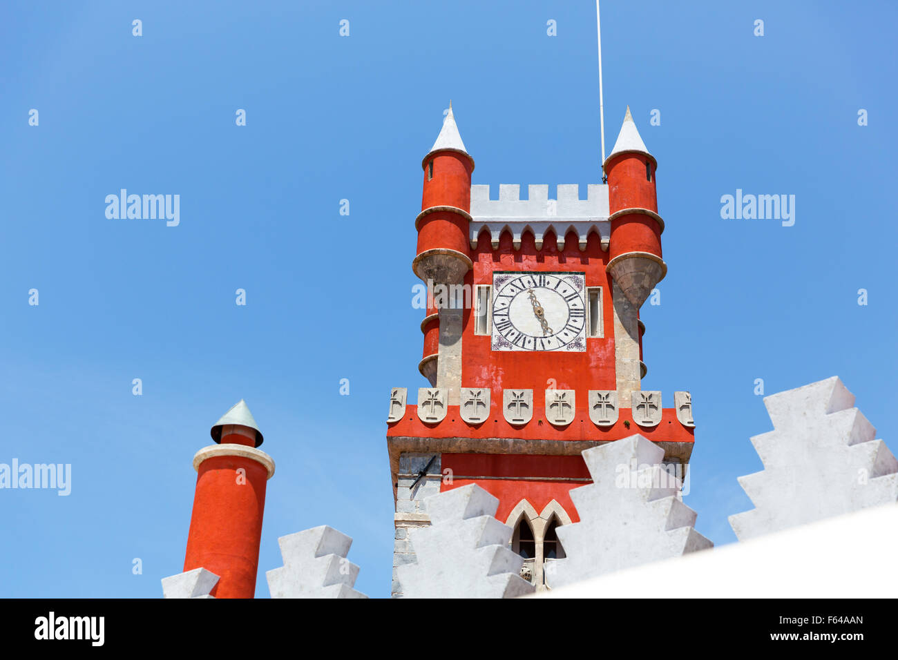Red castle tower with clock against the clear sky Stock Photo - Alamy