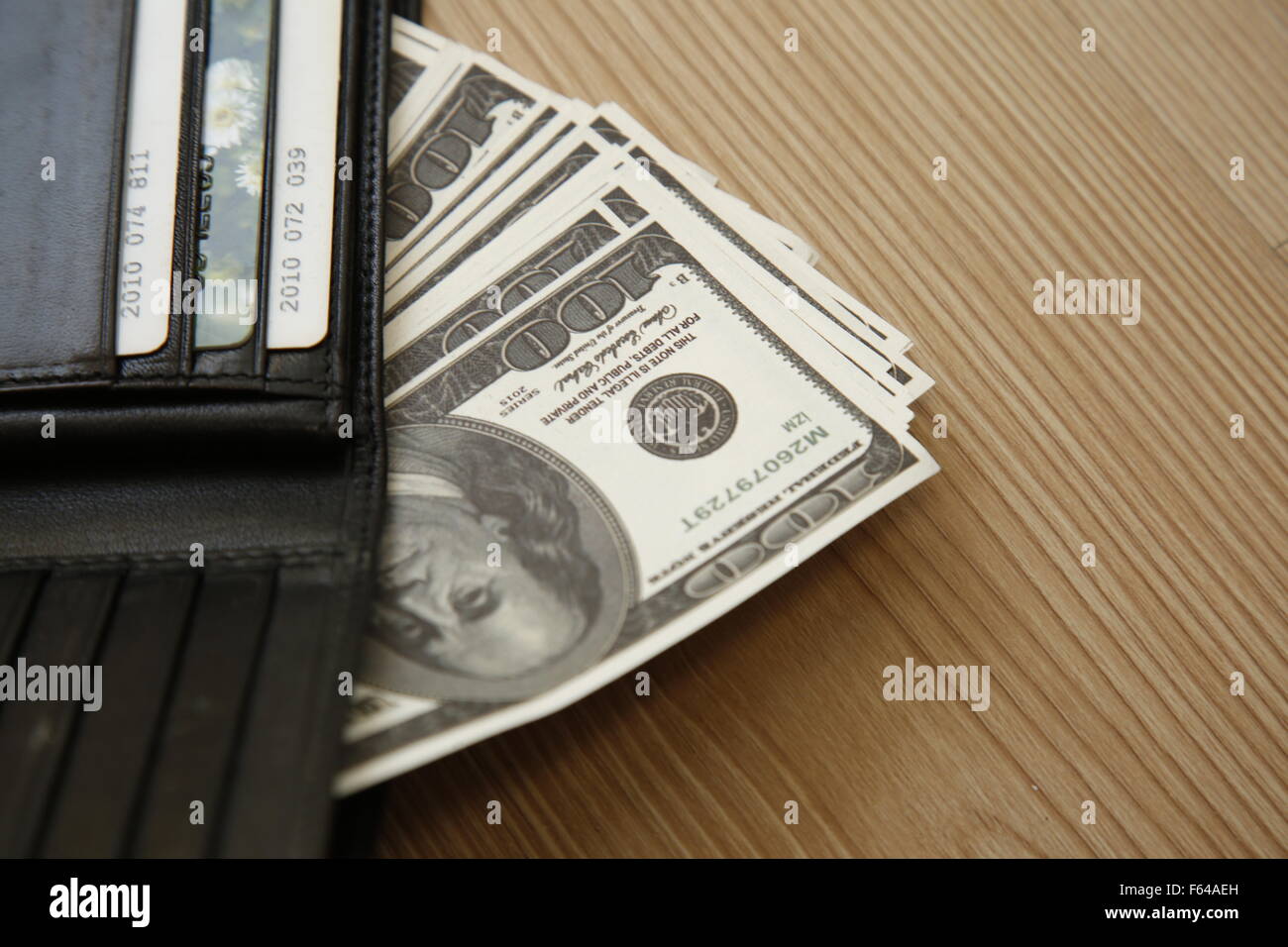 Black leather wallet full of money Stock Photo - Alamy