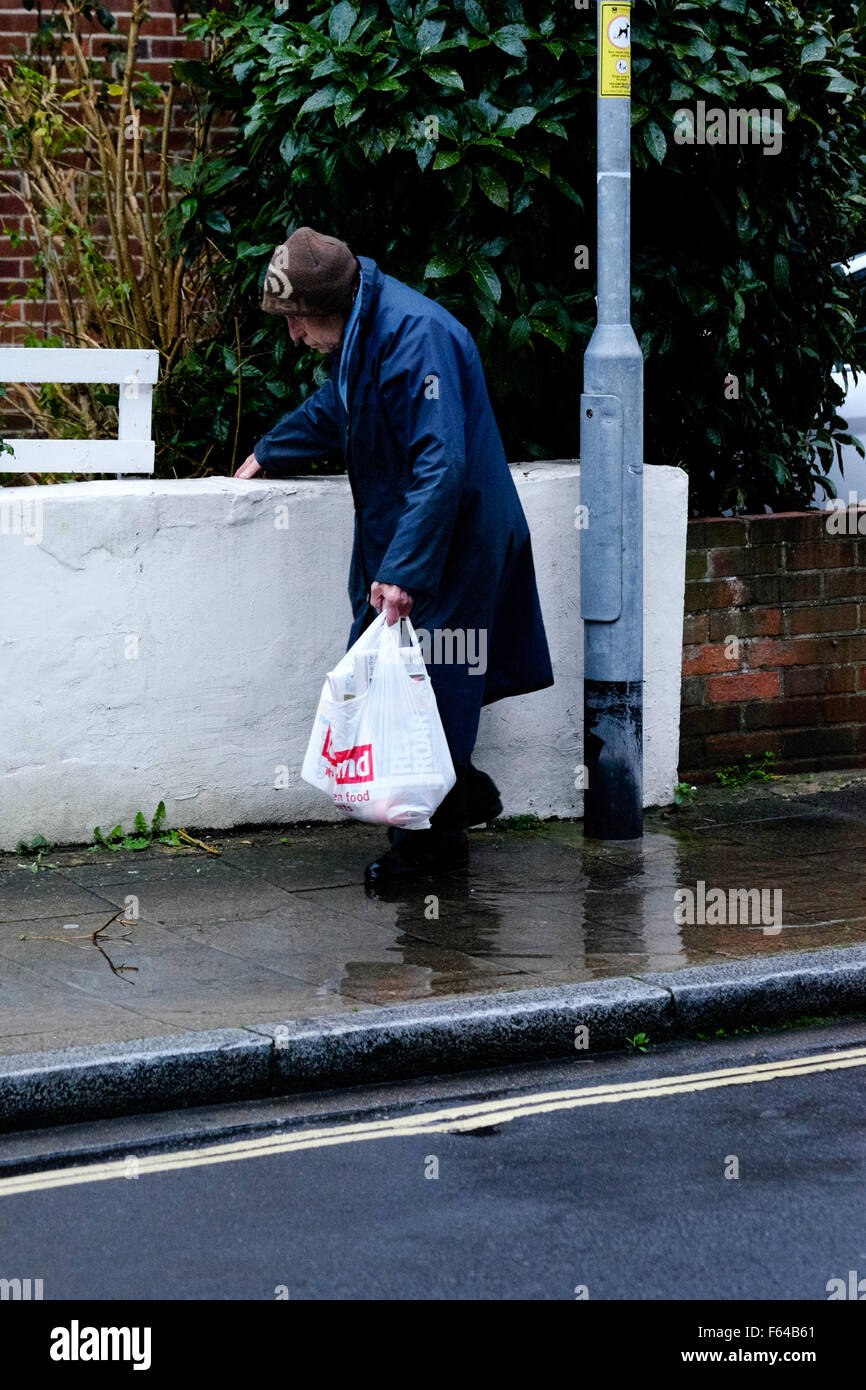 elderly man struggles to walk through a puddle uk Stock Photo - Alamy