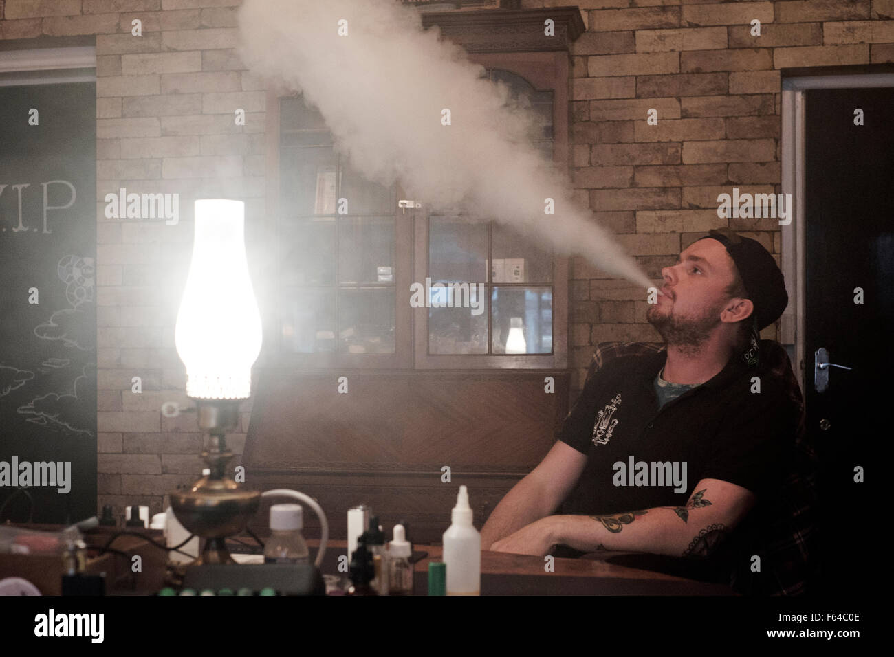man blows billowing clouds of vapour while vaping using an electronic ...