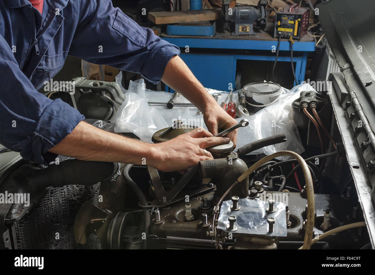 Auto mechanic working under the hood of an old car engine Stock Photo ...