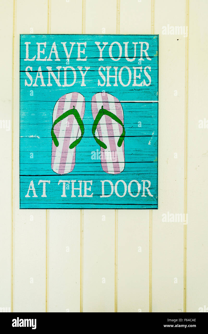 A sign at a beachside resort requesting, "Leave your sandy shoes at the ...