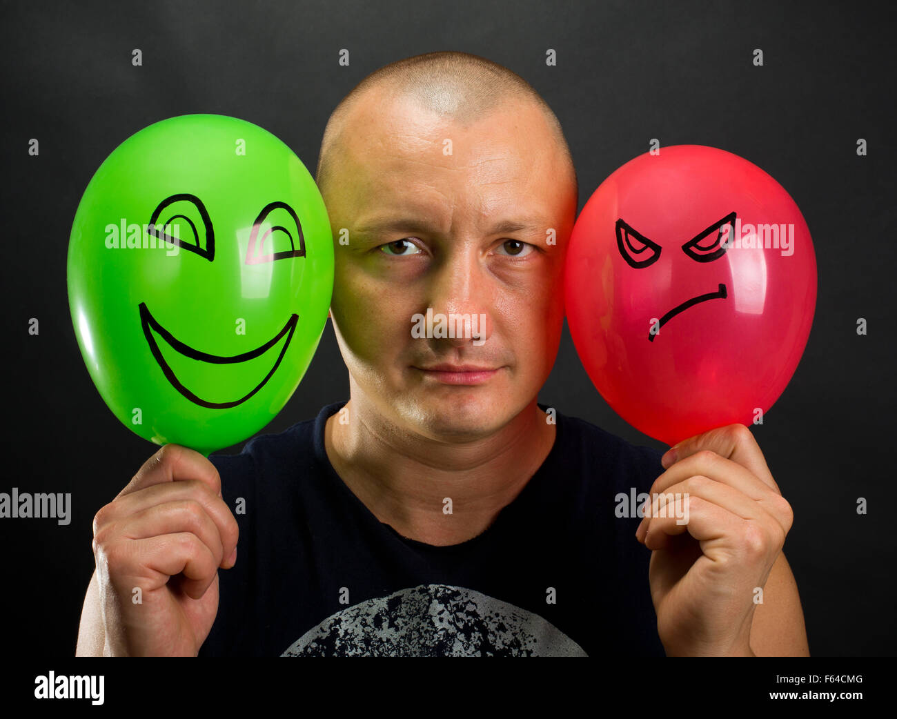Emotionless man between happy and angry balloons Stock Photo - Alamy
