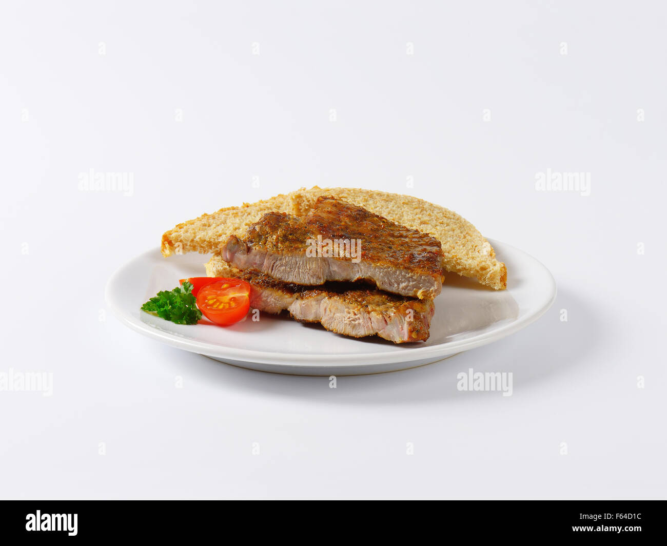 two slices of roasted pork meat with toast bread on white plate Stock ...