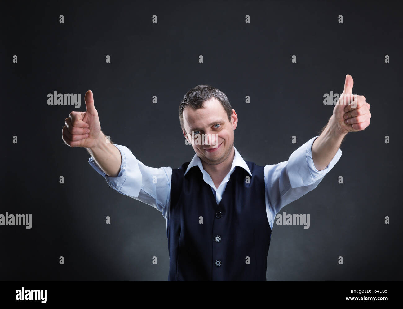 Happy businessman shows both thumbs up over grey Stock Photo - Alamy