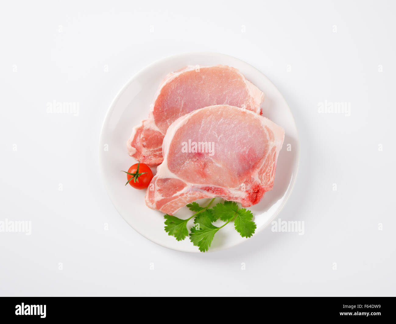 raw pork chops on white plate Stock Photo - Alamy