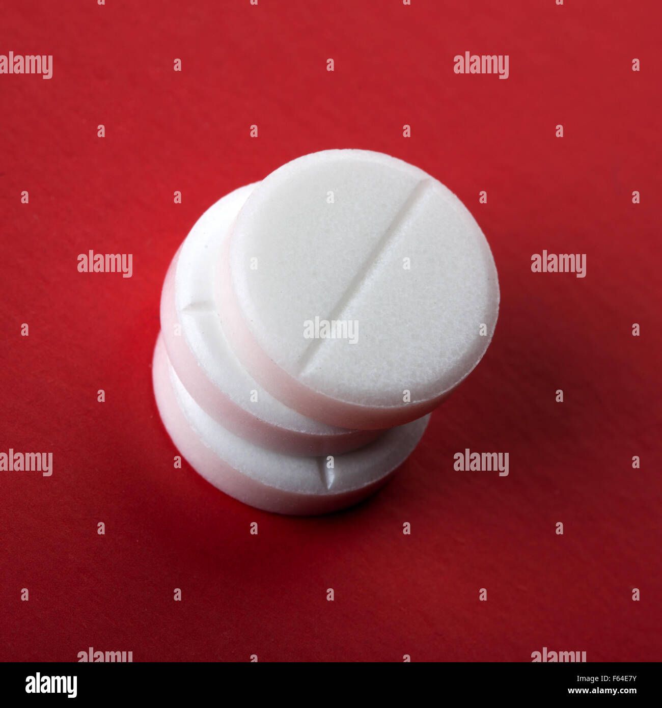 Closeup of three white tablets on red Stock Photo - Alamy