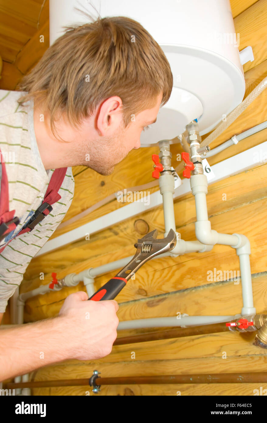 Plumber at work. Servicing boiler Stock Photo - Alamy
