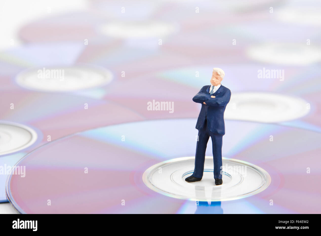 Small business man standing on computer CDs Stock Photo - Alamy