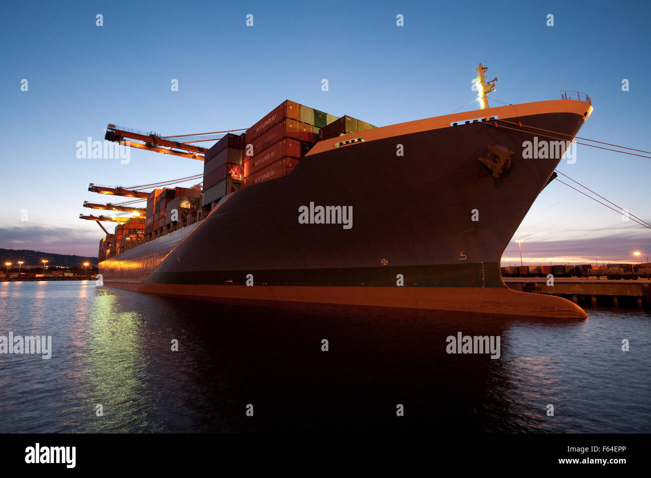 container ship loading at port facility at twilight night Stock Photo ...