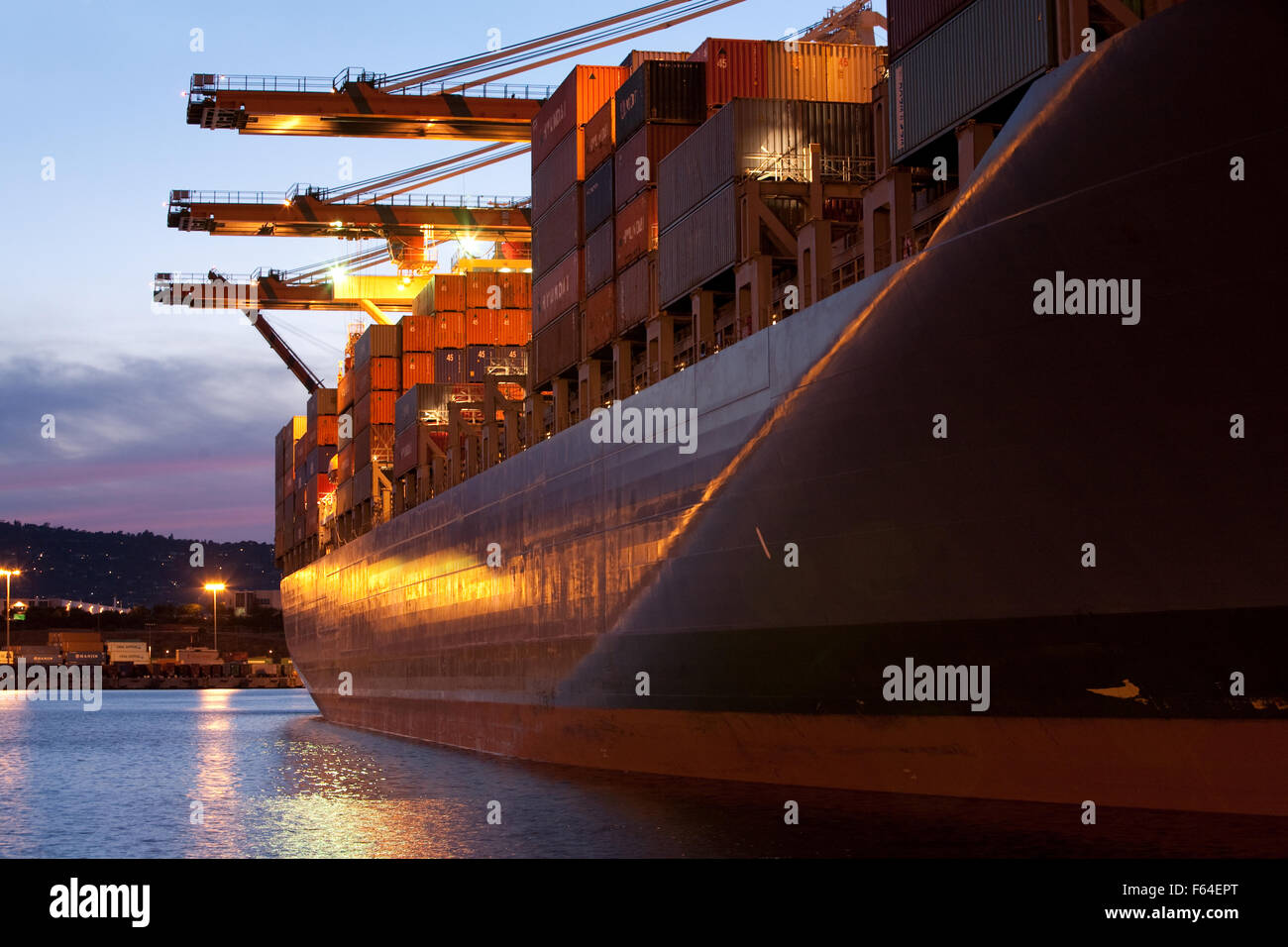 container ship loading at port facility at twilight night Stock Photo ...